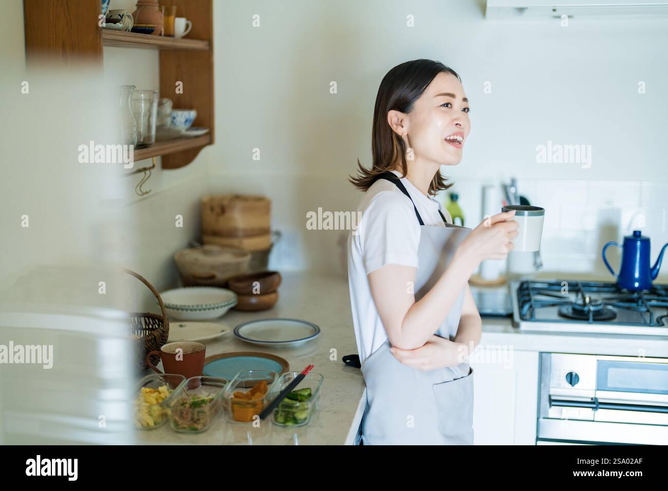 Woman relaxing in kitchen while cooking Stock Photo - Alamy