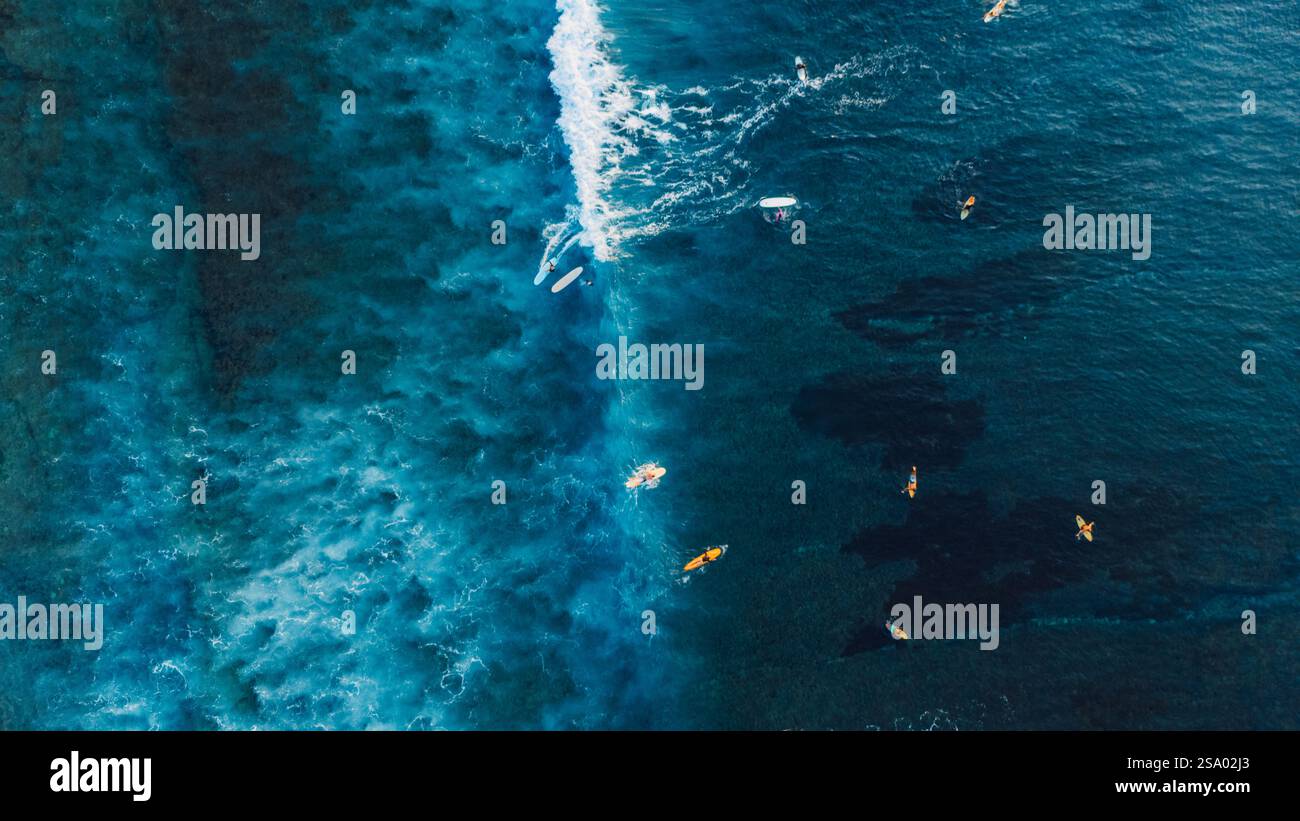 Aerial view of a lot of surfers during surfing on ocean waves. Waves ...