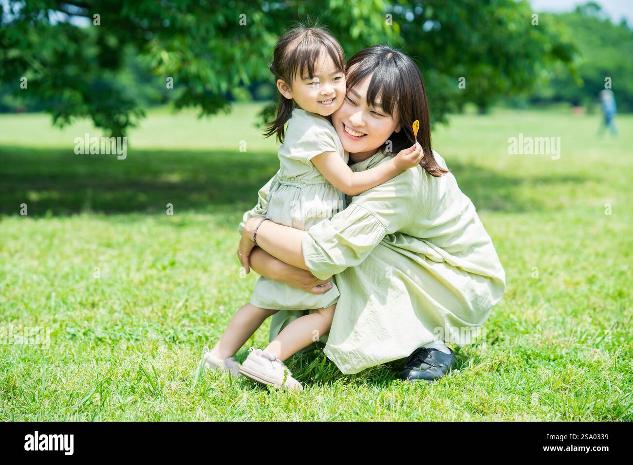 Parent and child hugging in the park Stock Photo - Alamy