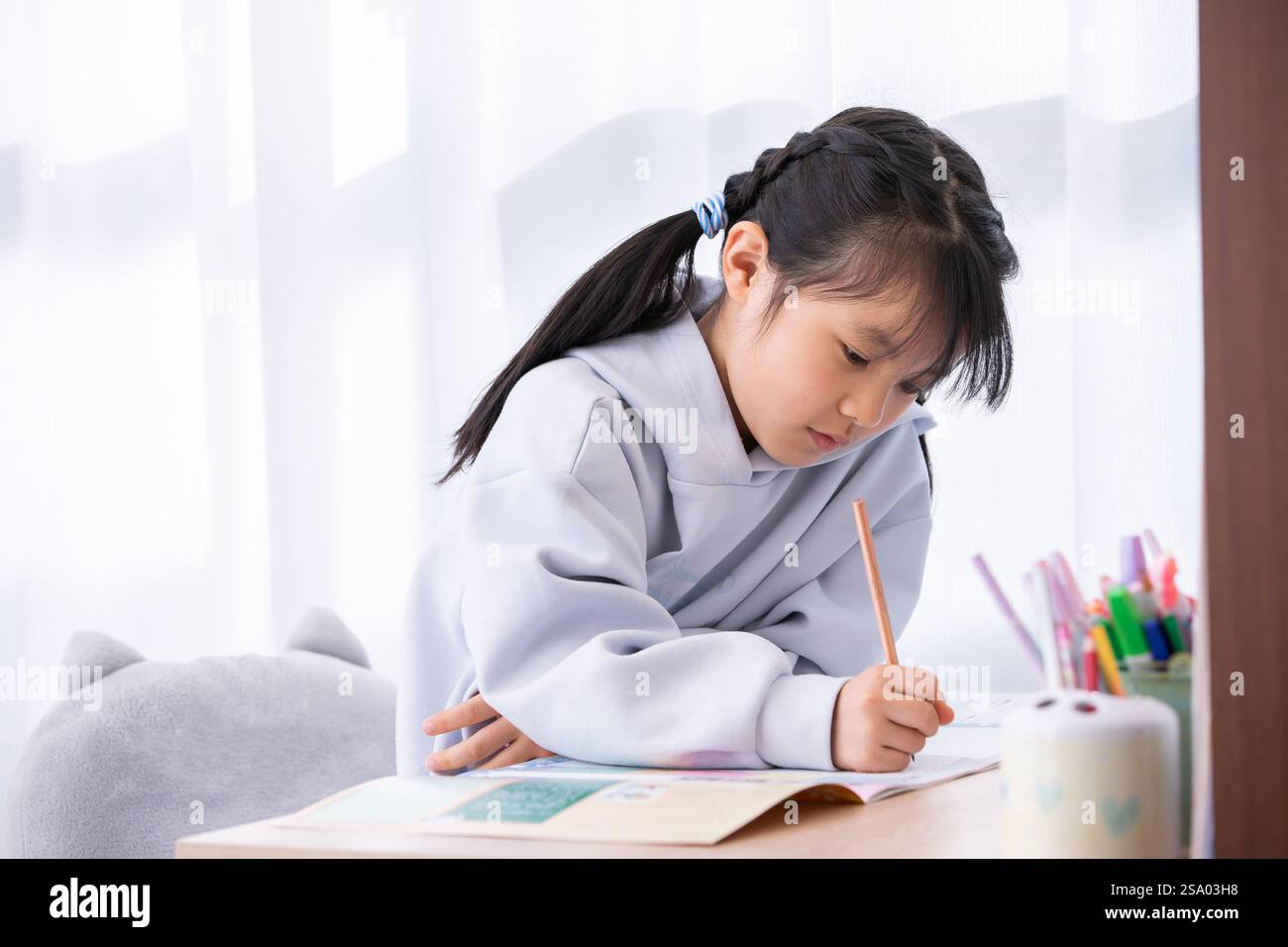 Primary school girl studying hard Stock Photo - Alamy
