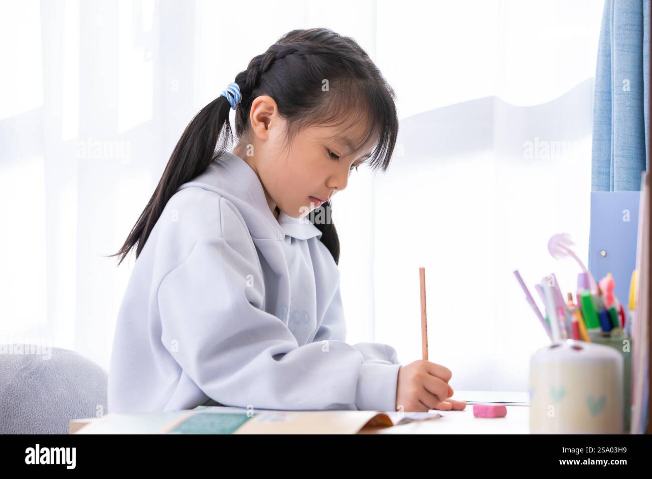 Primary school girl studying hard Stock Photo - Alamy