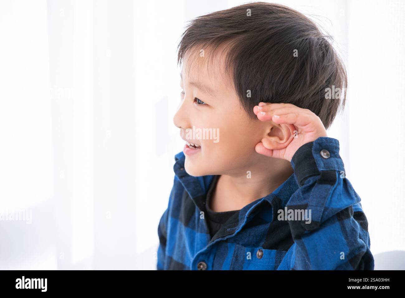 Child listening to a story with hands over ears Stock Photo - Alamy