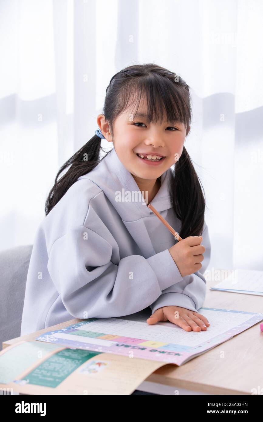 Elementary school girl studying at cram school Image Stock Photo - Alamy