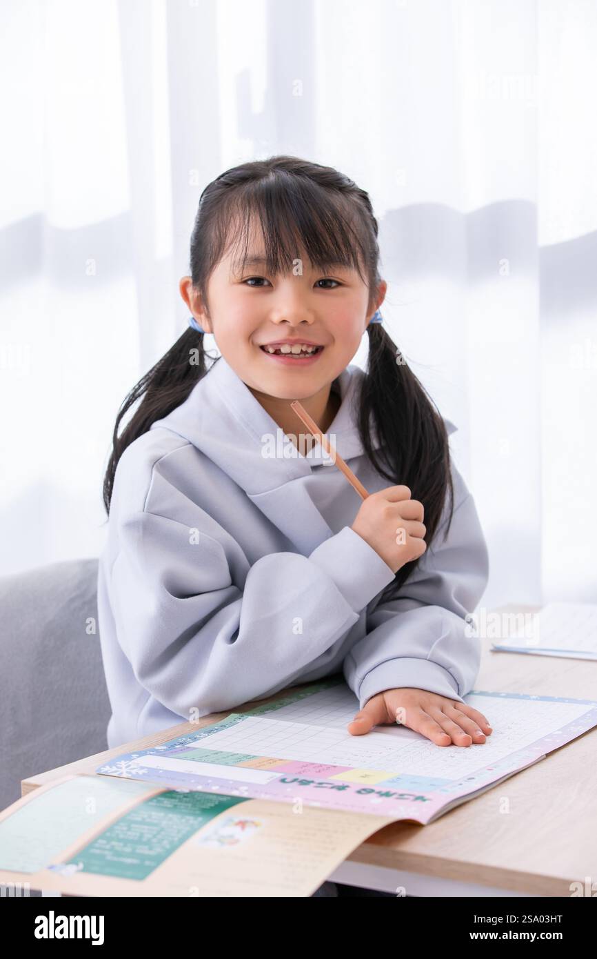 Elementary school girl studying at cram school Image Stock Photo - Alamy