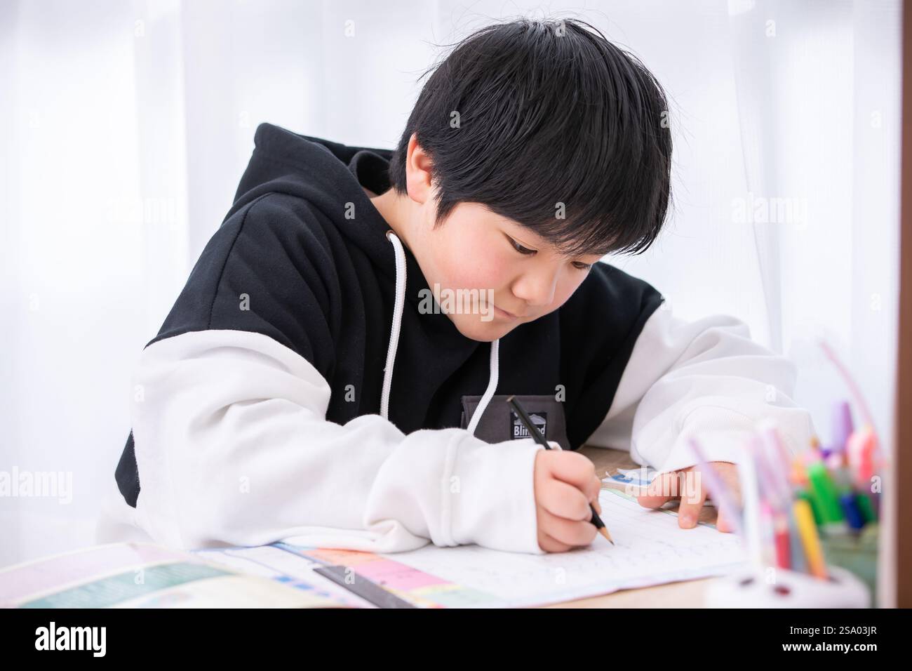 Primary school boy solving a problem in a problem book Stock Photo - Alamy