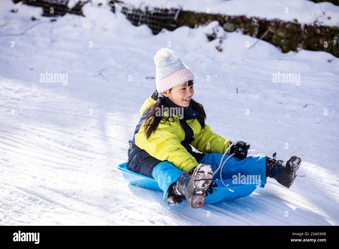 Girl playing on the sled Stock Photo - Alamy