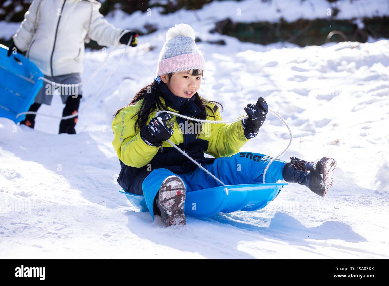 Two children playing on the sled Stock Photo - Alamy