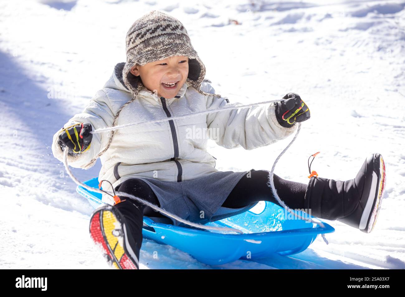 Child enjoying sledging Stock Photo - Alamy