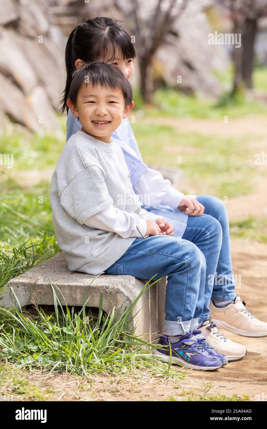 Smiling child sitting on a bench Smile Stock Photo - Alamy