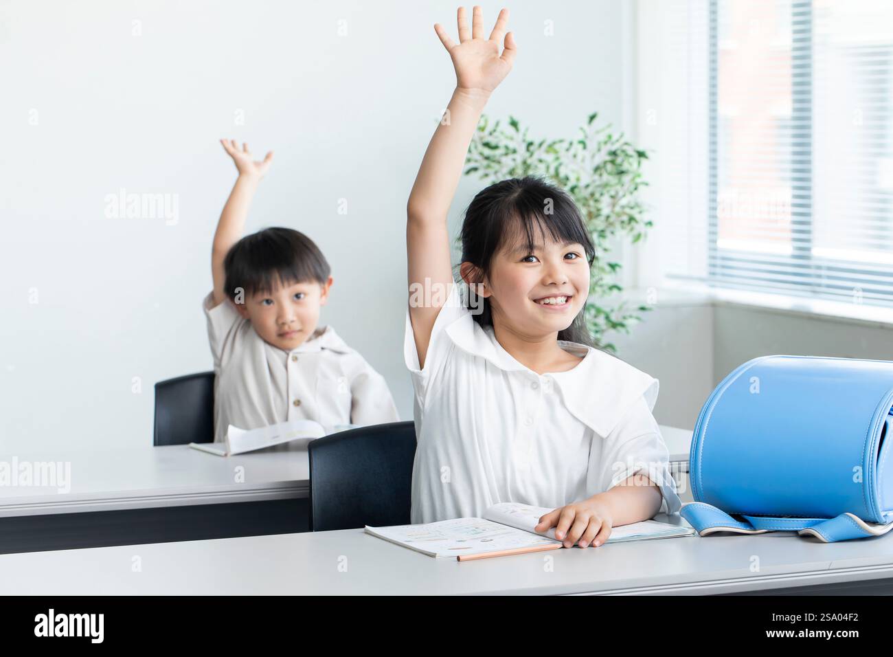 Student raising hand to speak in class Stock Photo - Alamy