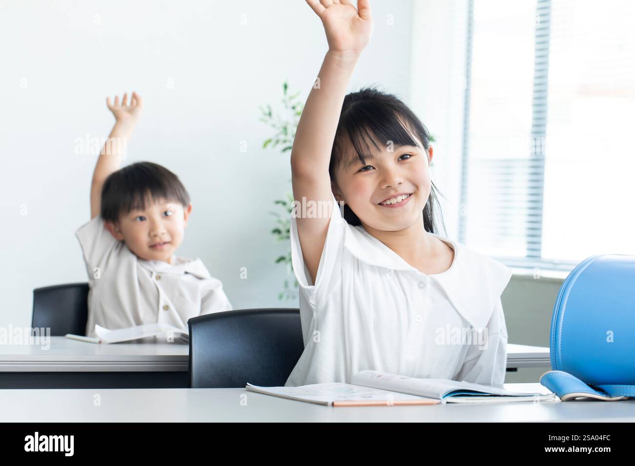 Student raising hand to speak in class Stock Photo - Alamy