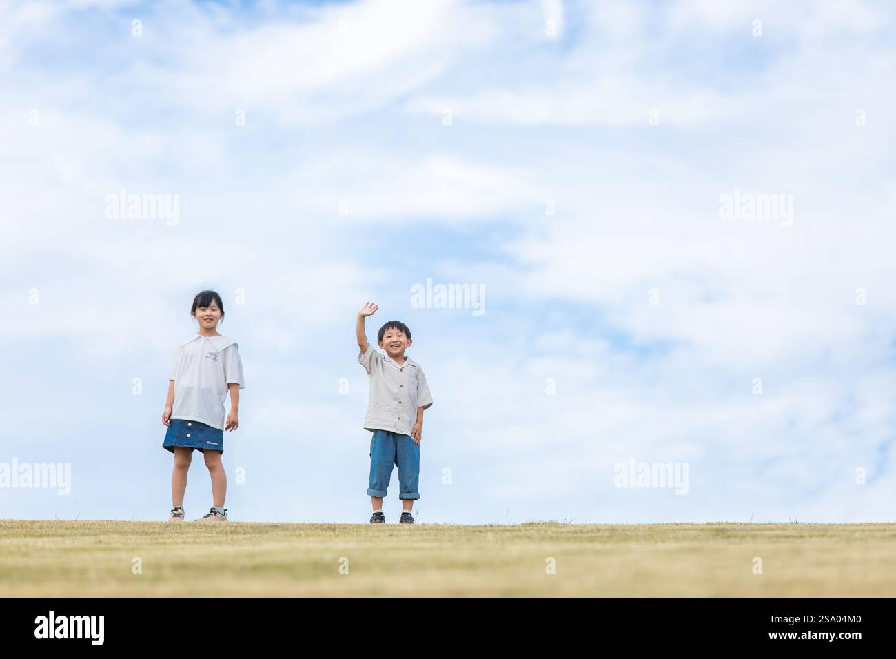 Child waving from hill Stock Photo - Alamy