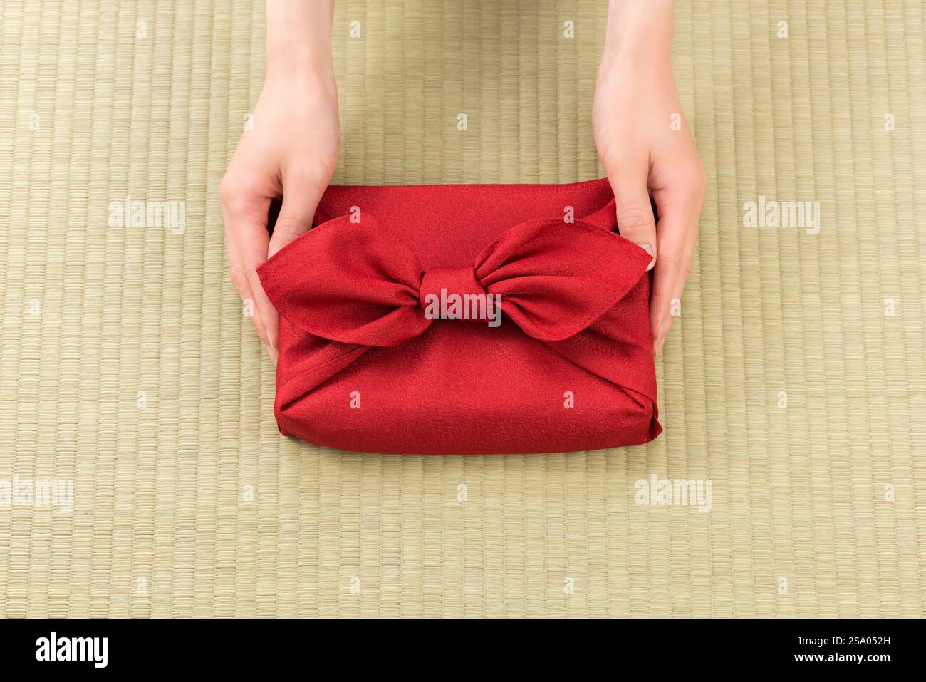 Woman's hand handing over a bath-wrapped souvenir Stock Photo - Alamy