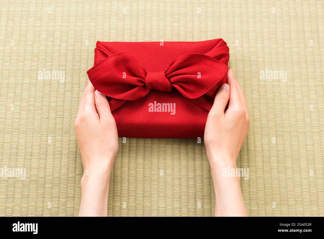 Woman's hand handing over a bath-wrapped souvenir Stock Photo - Alamy