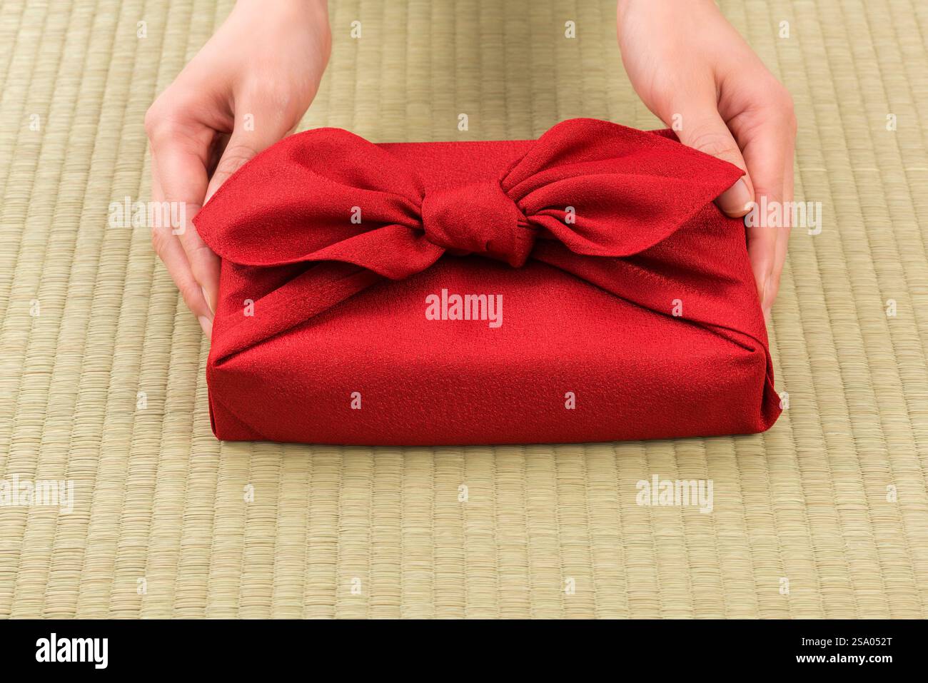 Woman's hand handing over a bath-wrapped souvenir Stock Photo - Alamy