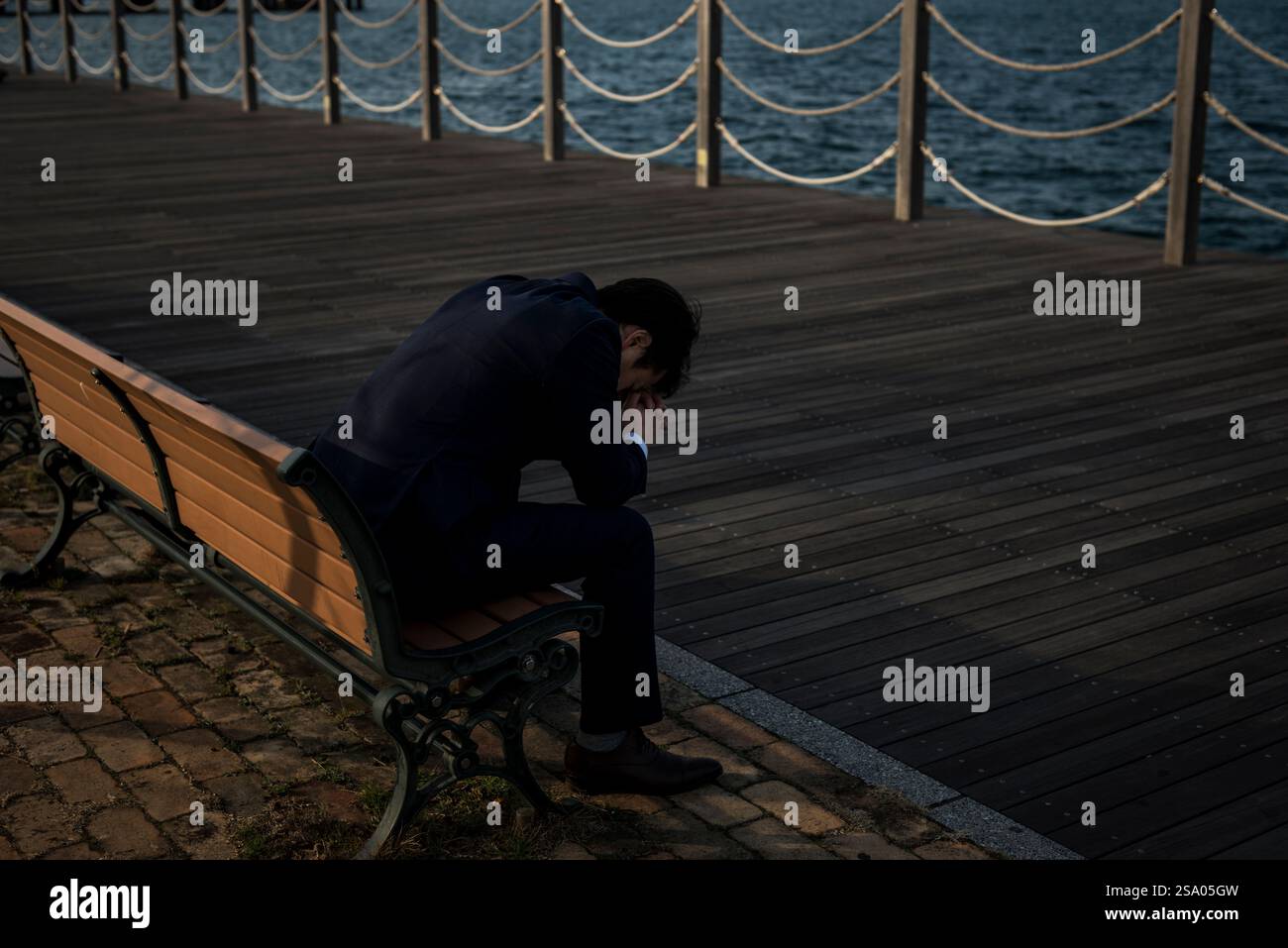 Businessman drooping on park bench Stock Photo - Alamy