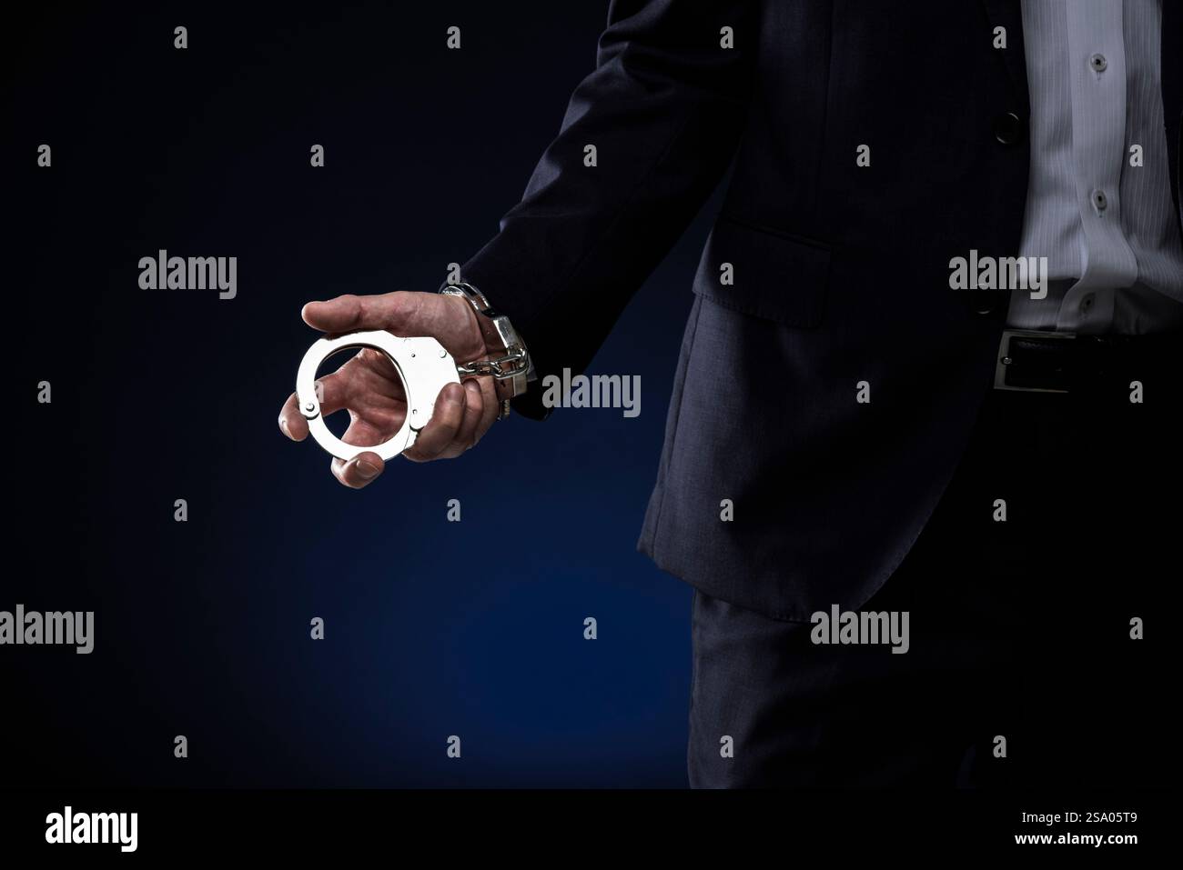 Handcuffs and male hand in suit Stock Photo - Alamy