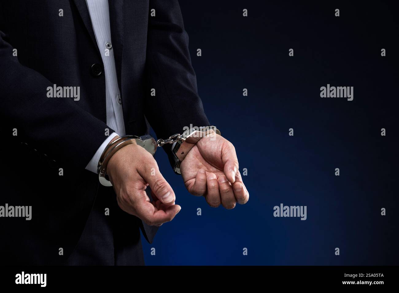 Handcuffed man in suit with handcuffs Stock Photo - Alamy
