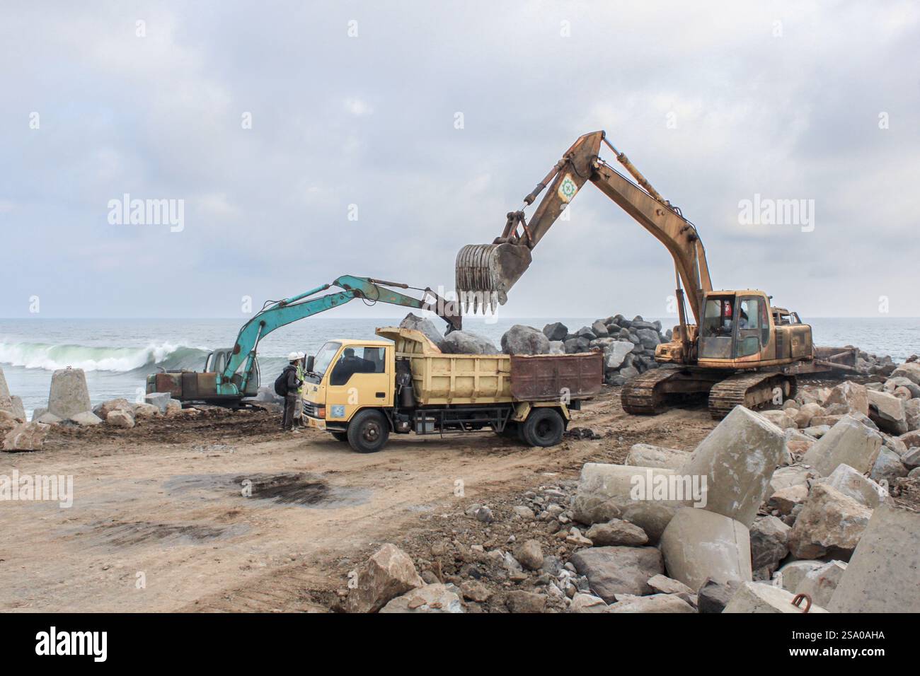 Construction workers operating heavy machinery to develop a wave ...