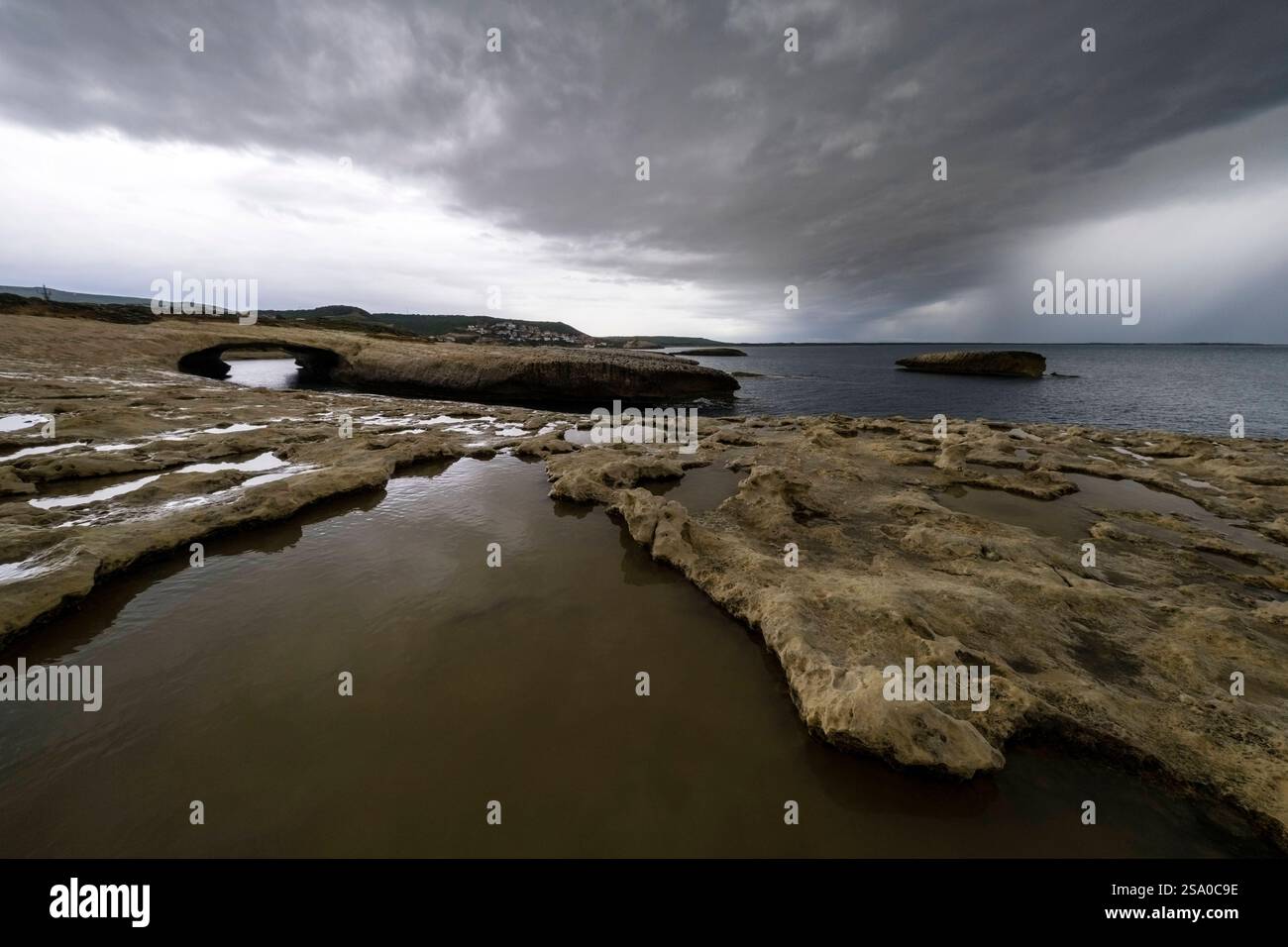 Rainwater in small water holes on the rocky coast of S Archittu, Arco ...