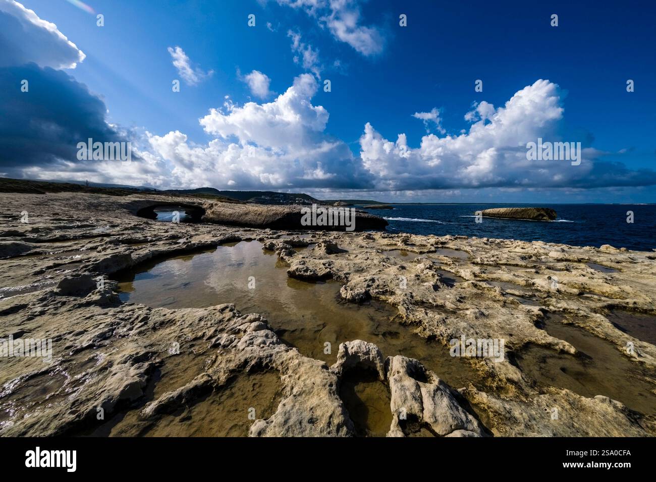 Rainwater in small water holes on the rocky coast around Arco di S ...