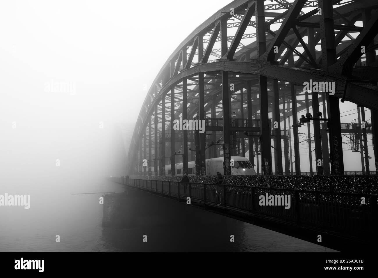 A Train Crosses A Large Iron Bridge Shrouded In Thick Fog With Minimal a-train-crosses-a-large-iron-bridge-shrouded-in-thick-fog-with-minimal