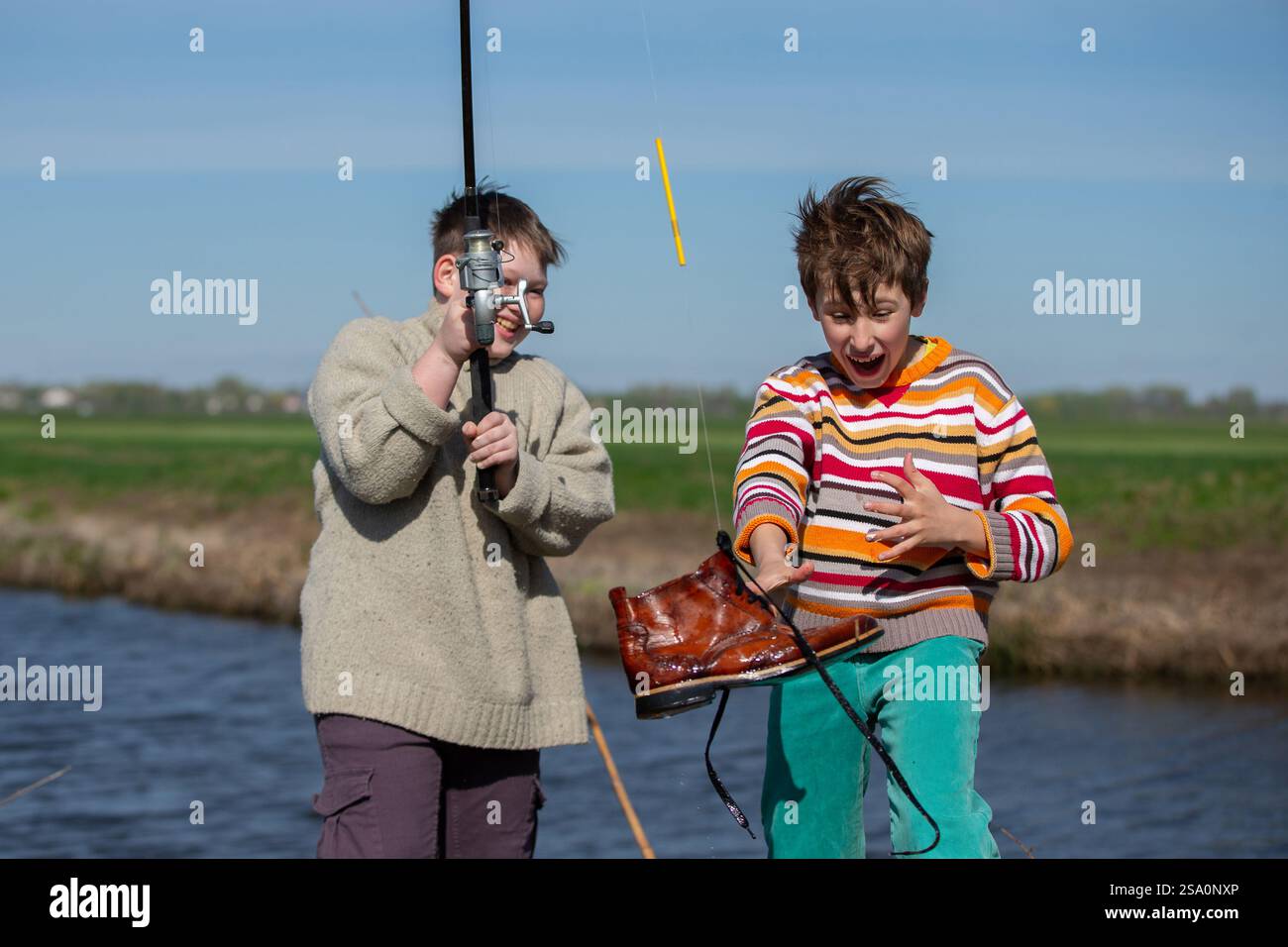 Funny fishing. Two of the boy's friends hooked an old shoe with a ...