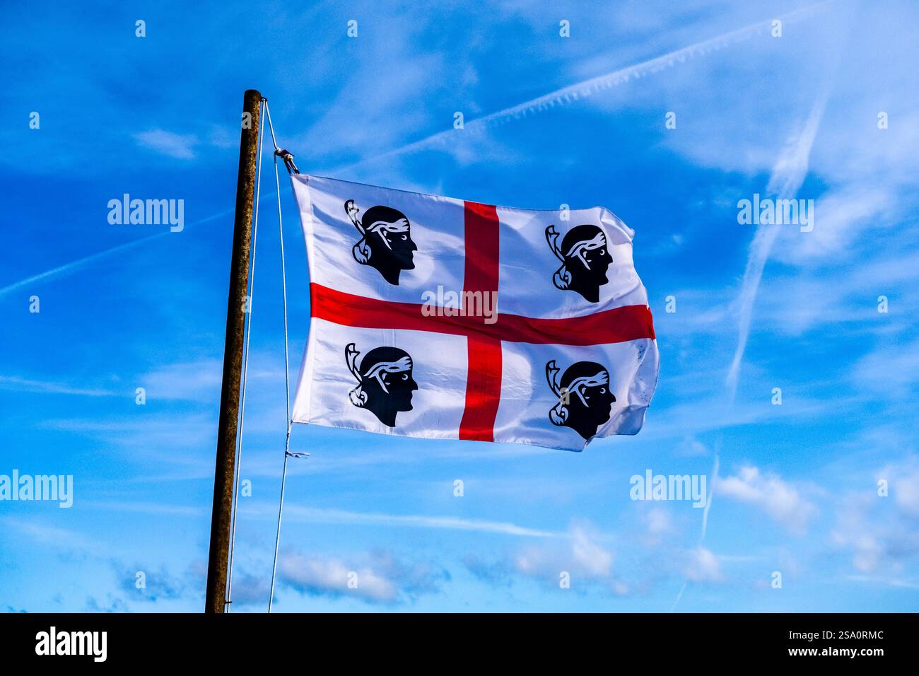 The Sardinian flag, also called the Four Moors, flutters in the wind in the small coastal town ...
