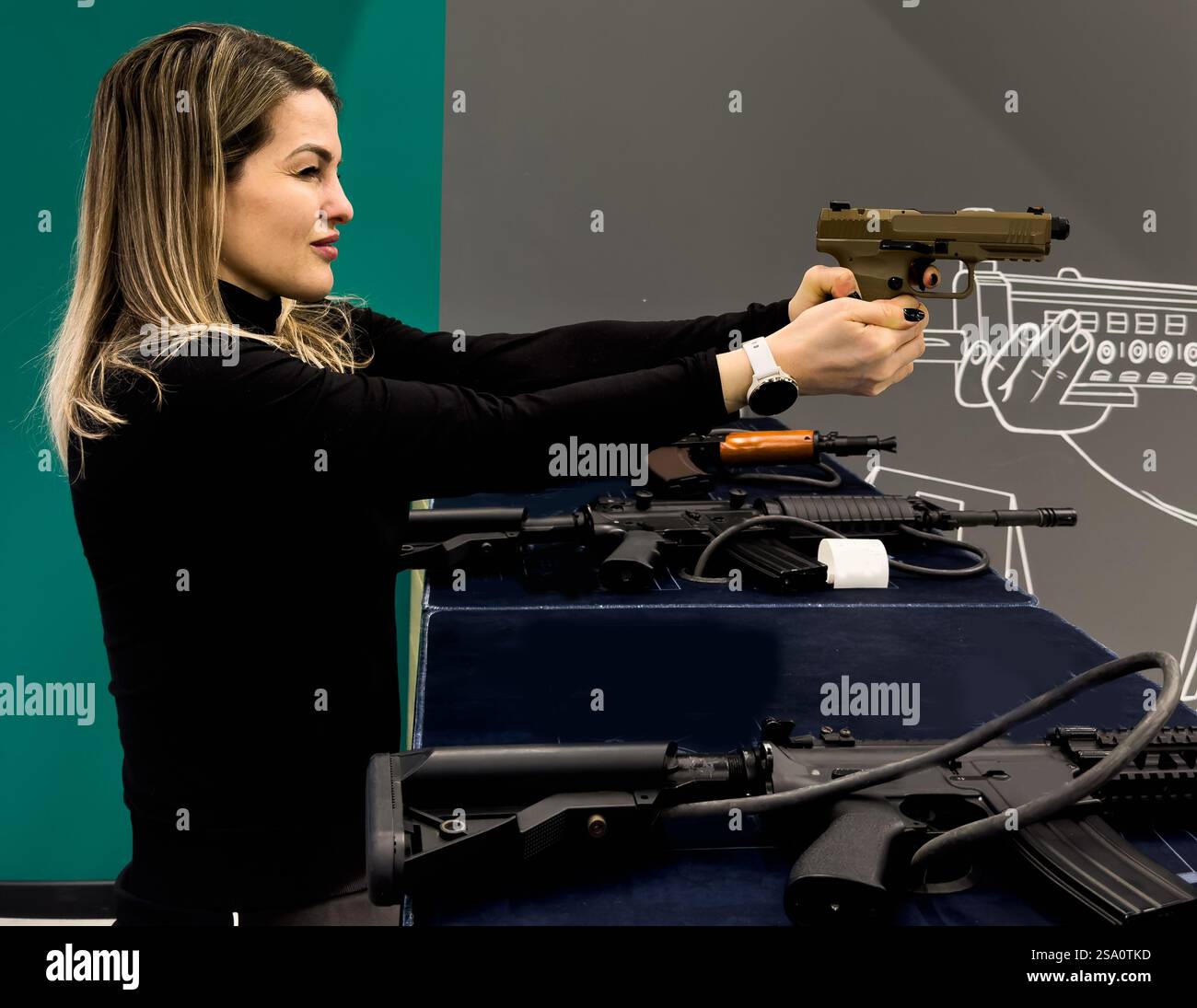 Woman aiming pistol at target out indoor firing range or shooting range ...