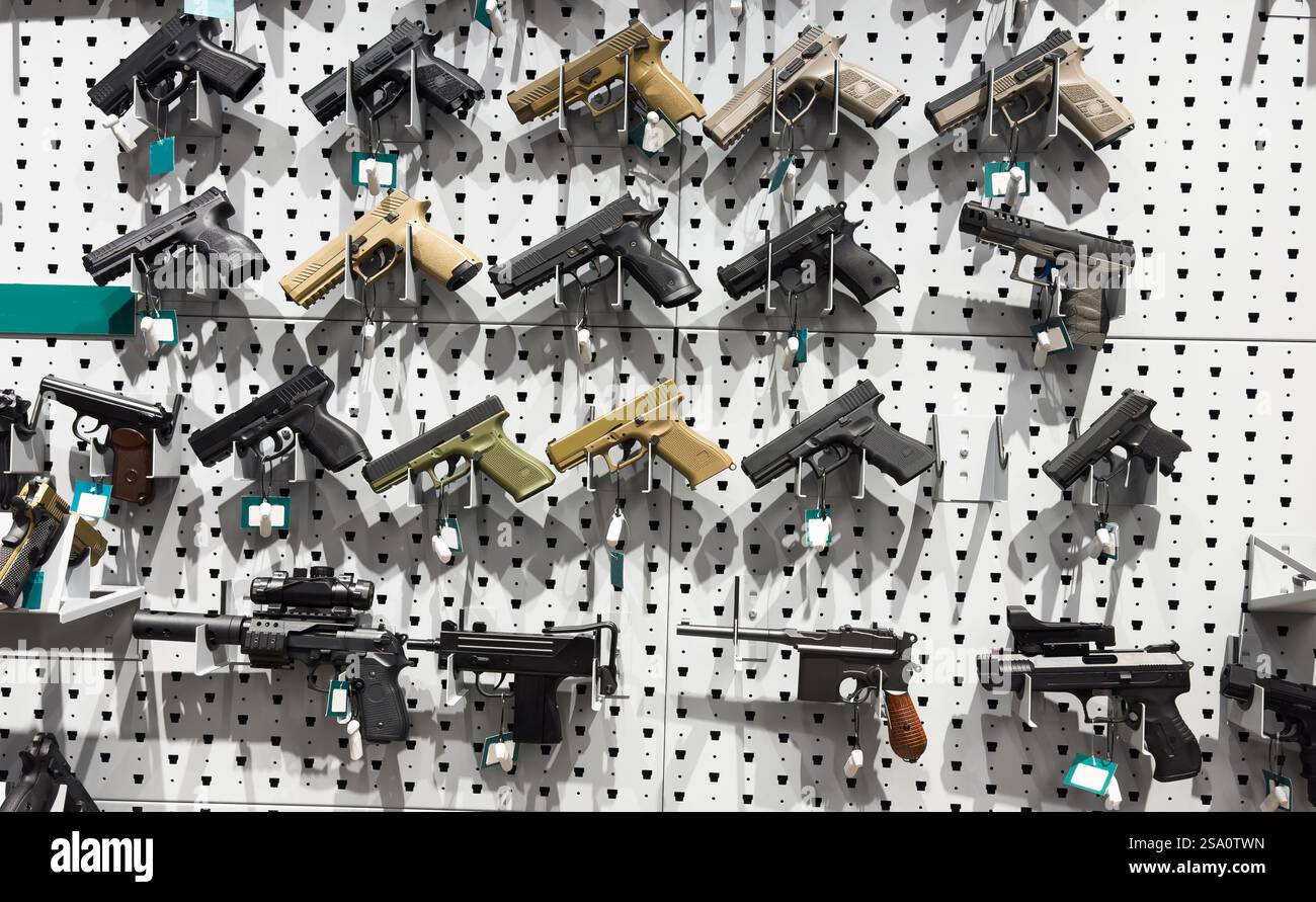 Gun shop interior with various handguns displayed on wall rack Stock ...