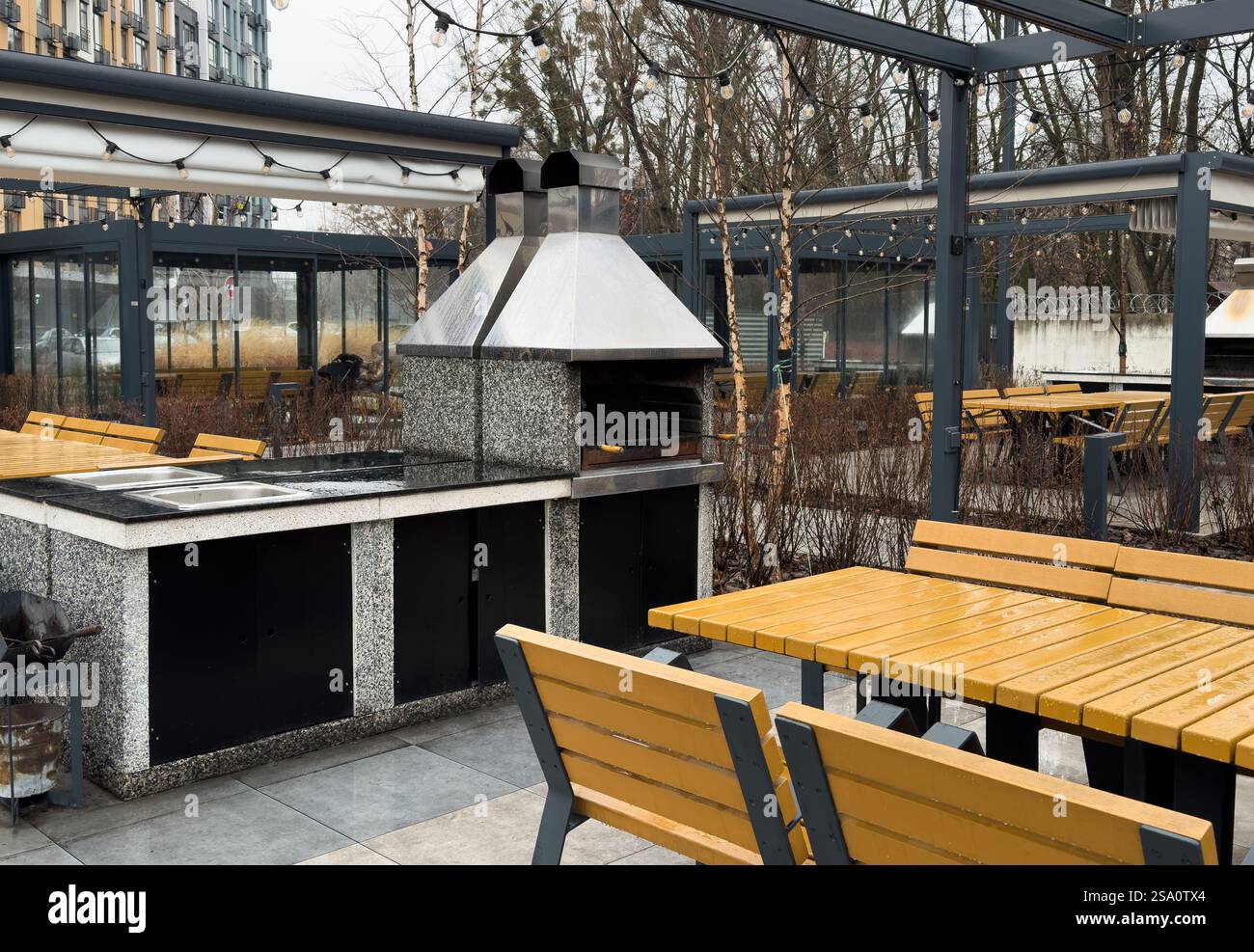 Beautiful backyard with barbeque area and dining table Stock Photo - Alamy