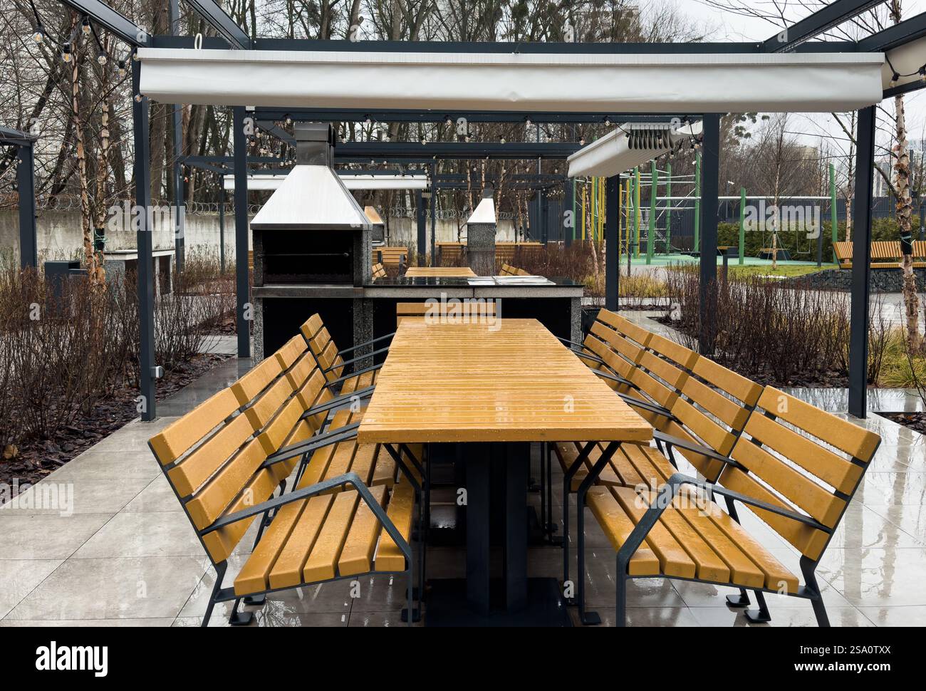 Beautiful backyard with barbeque area and dining table Stock Photo - Alamy