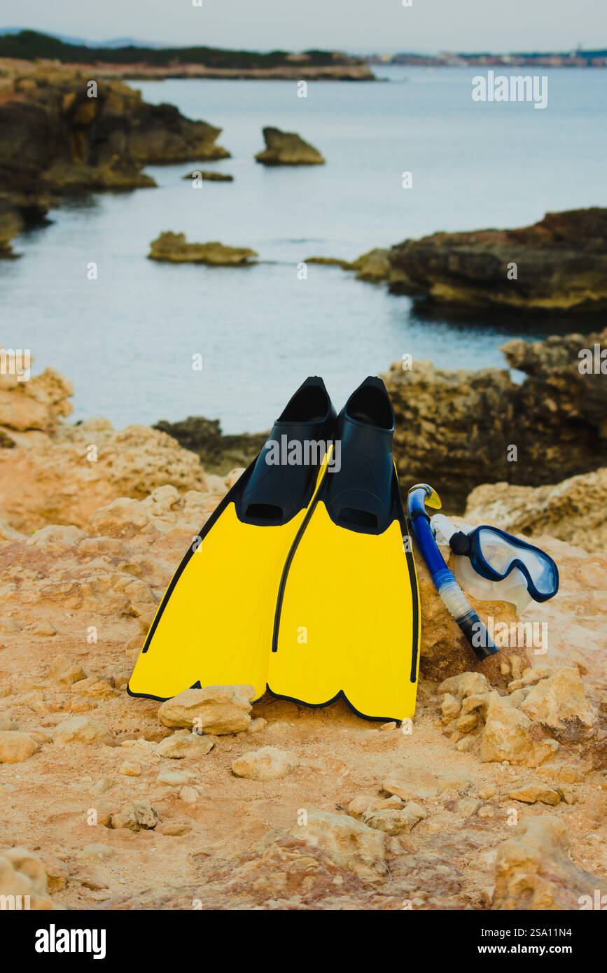 Yellow fins and snorkel mask on the sea cliff. Water sports in natural ...