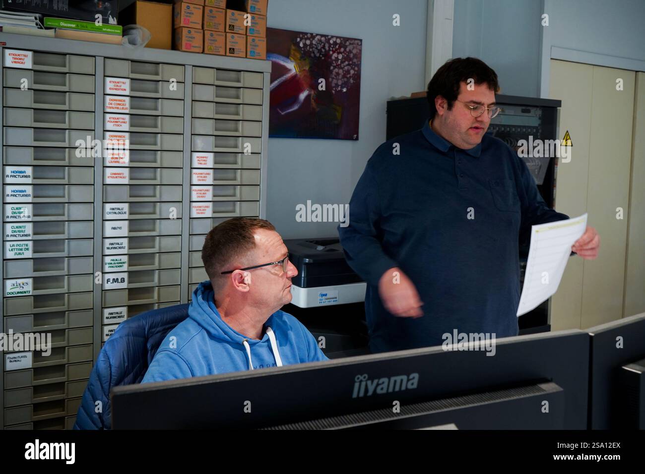 Disabled worker and his monitor working in the printing, reprography ...