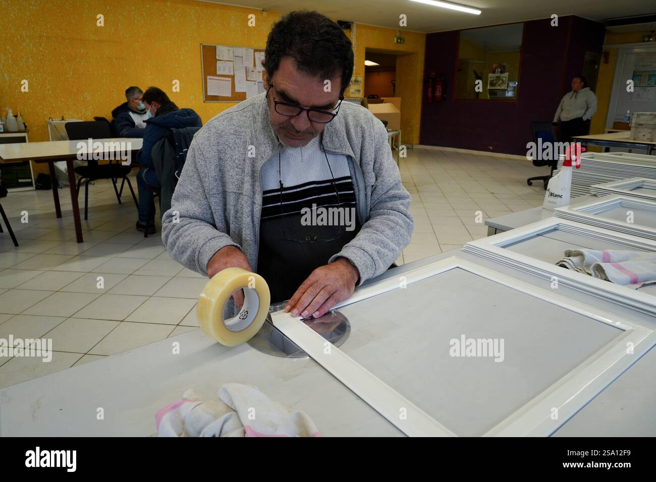 Disabled worker working in the shaping and packaging workshop. Quality ...