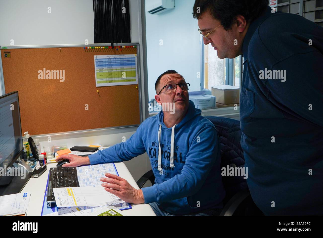 Disabled worker and his monitor working in the printing, reprography ...