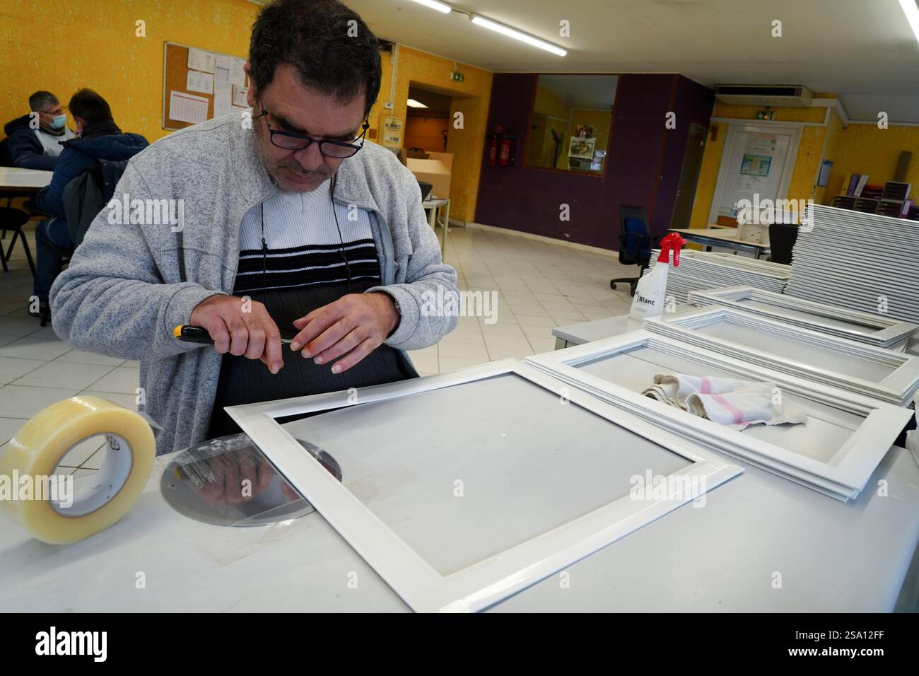 Disabled worker working in the shaping and packaging workshop. Quality ...