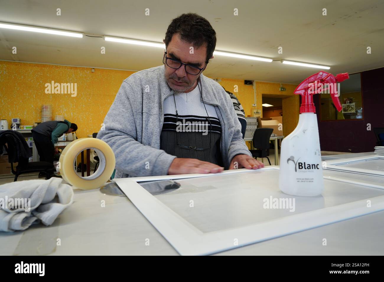 Disabled worker working in the shaping and packaging workshop. Quality ...