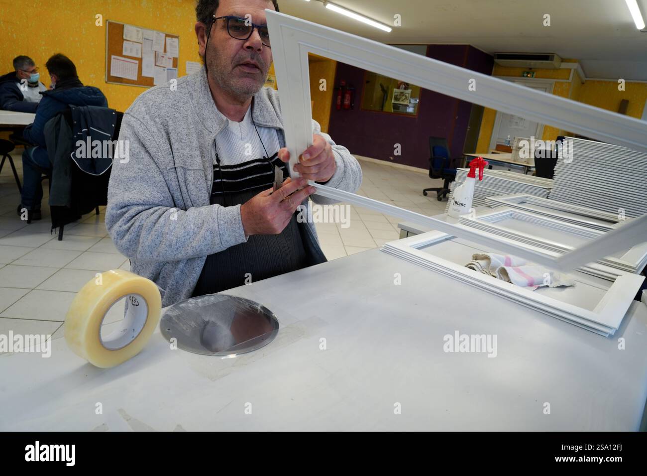 Disabled worker working in the shaping and packaging workshop. Quality ...