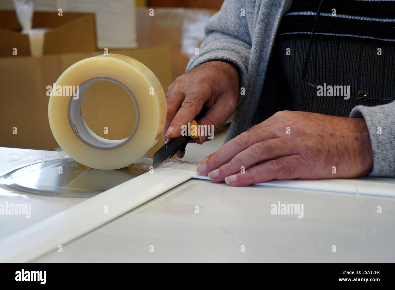 Disabled worker working in the shaping and packaging workshop. Quality ...