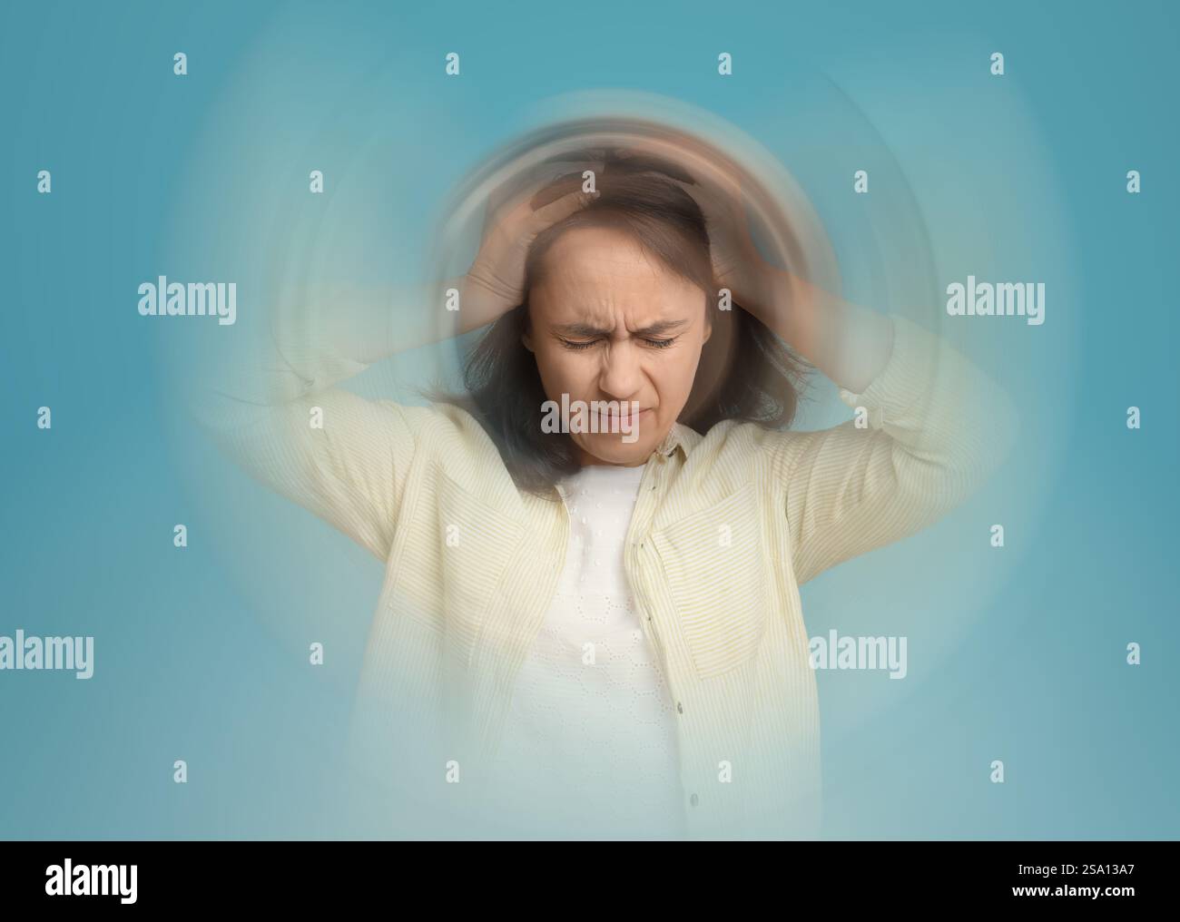 Woman suffering from headache and dizziness on light blue background ...