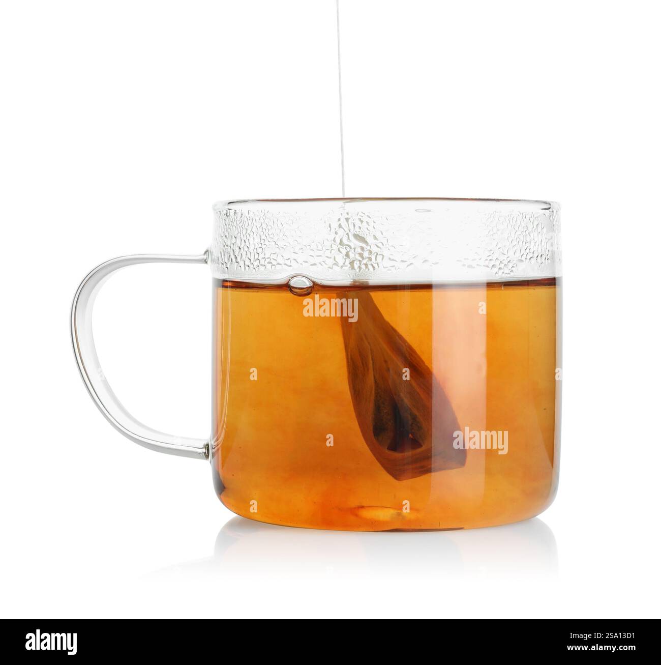 Putting tea bag into glass cup on white background Stock Photo - Alamy