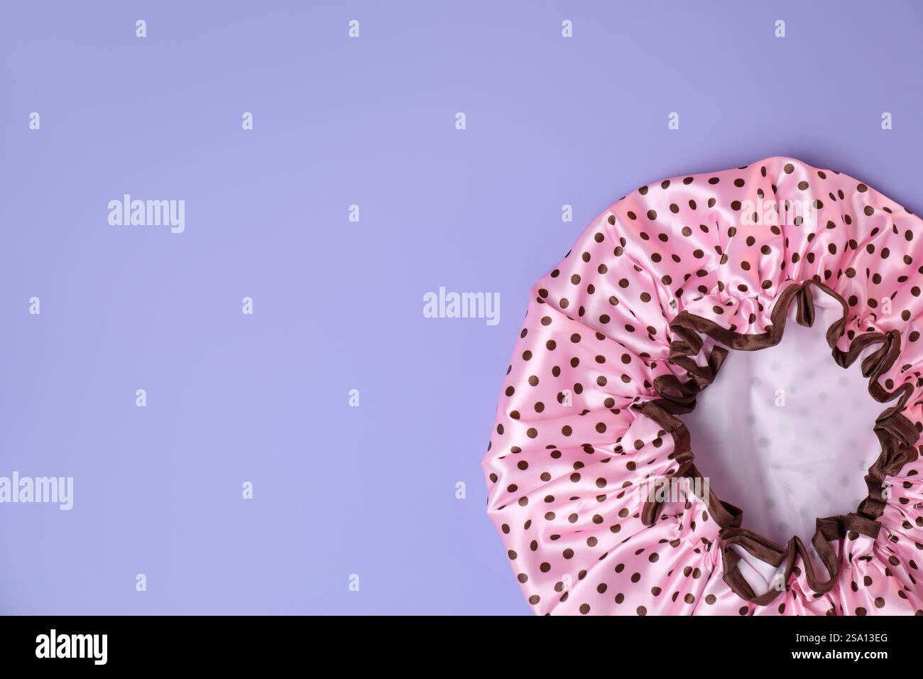 One shower cap on lilac background, top view. Space for text Stock ...