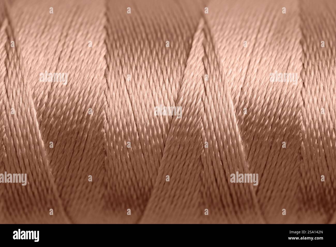 Sewing thread in mocha mousse shade, closeup. Trendy color of 2025 year ...
