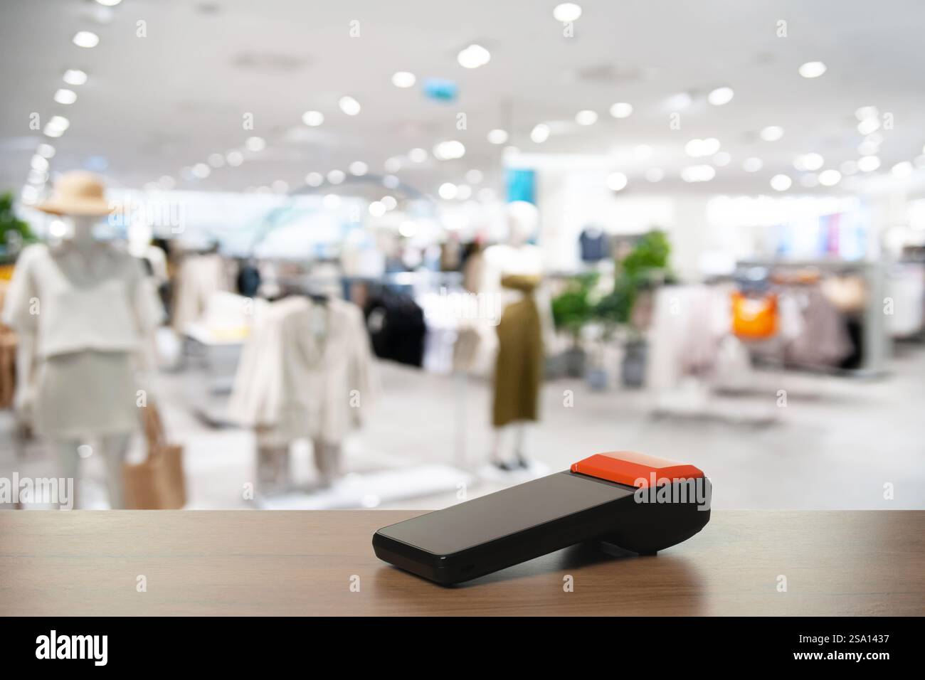 Payment terminal on wooden counter in clothes store Stock Photo - Alamy