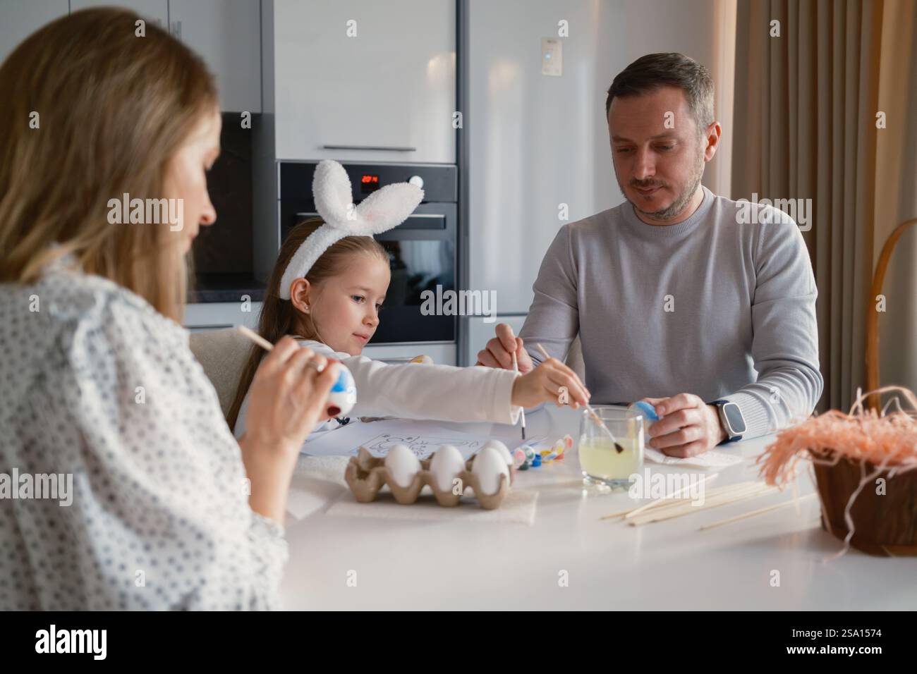 Family enjoying Easter preparation and coloring eggs in a cozy home ...