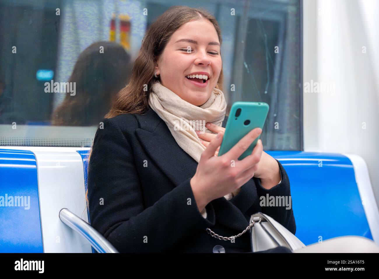 Happy Young Woman Laughing While Using Smartphone on Subway Train Stock ...