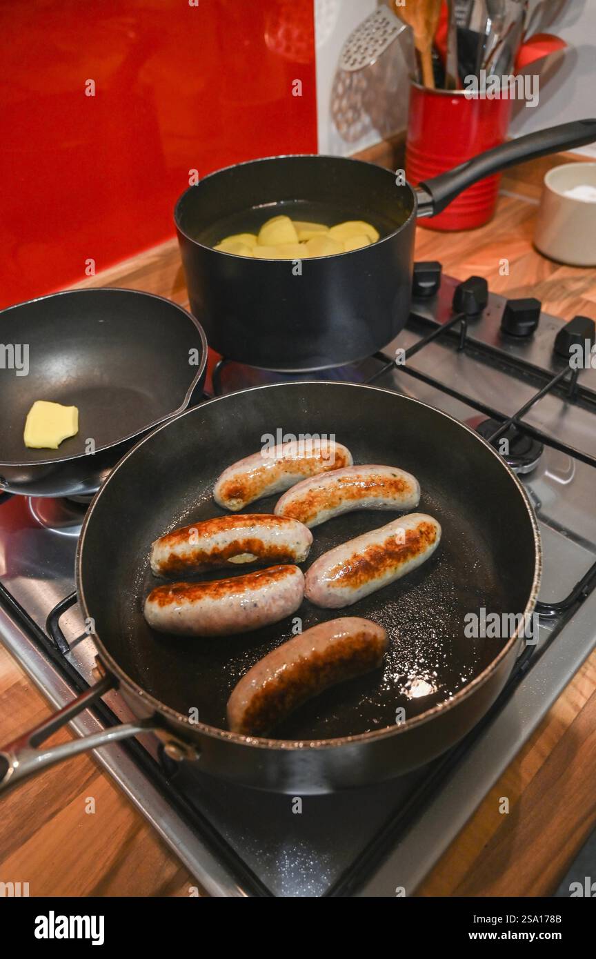 Home cooking browning off pork sausages in a frying pan : Credit Simon ...
