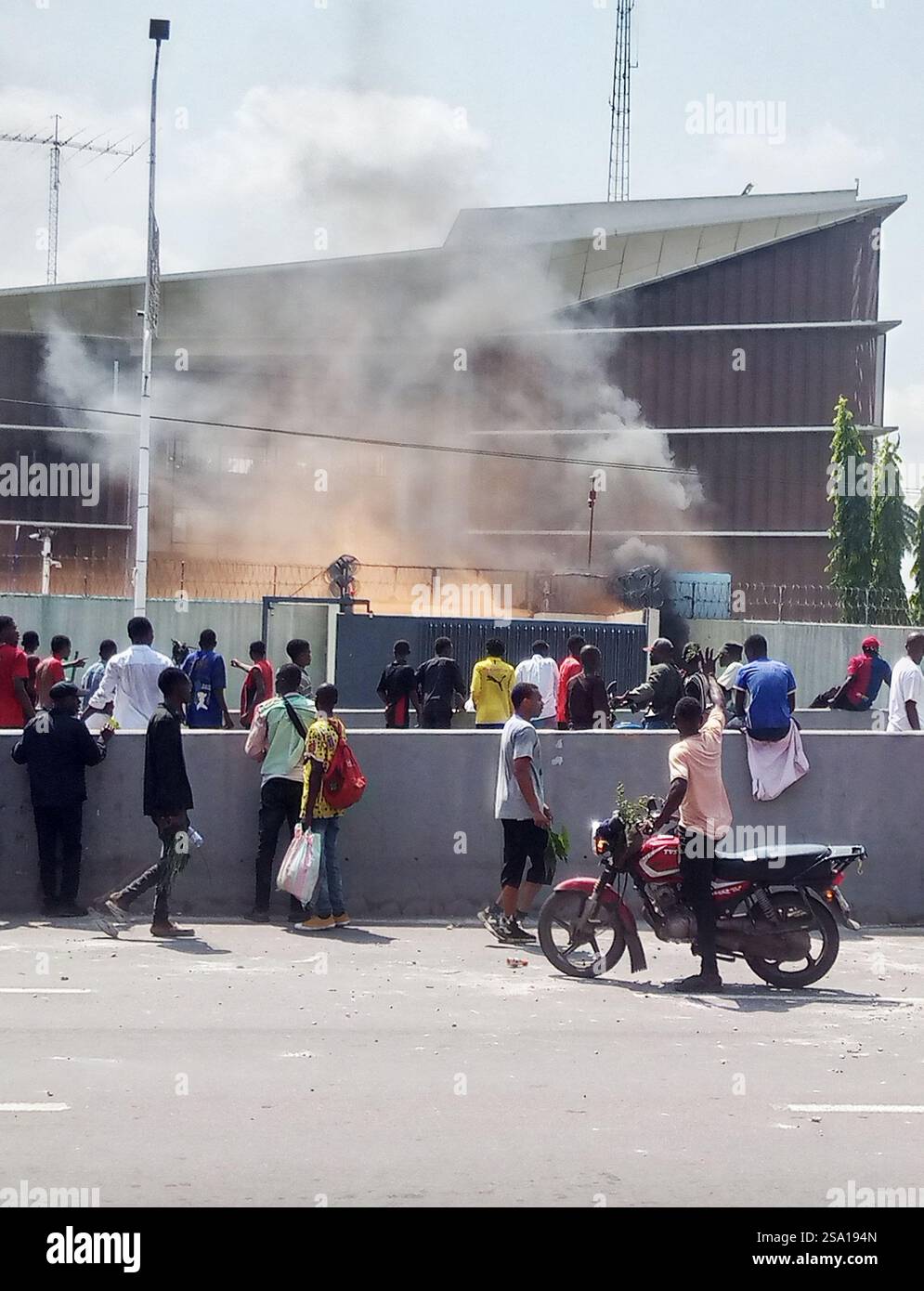 Street scene with people watching the flames of some burning tyres at ...