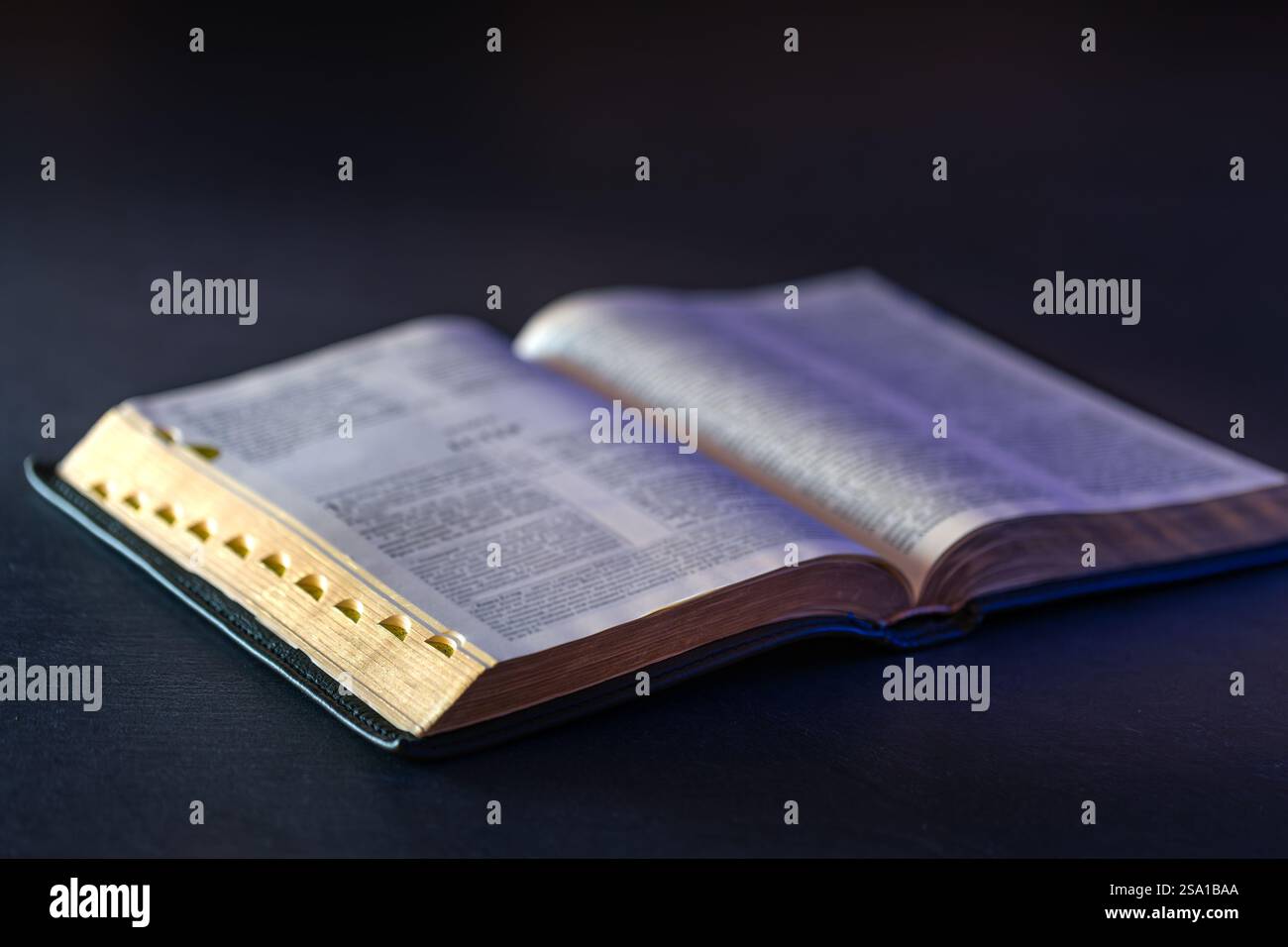 Open Holy Bible on the table. Religion concept. Bible on black ...